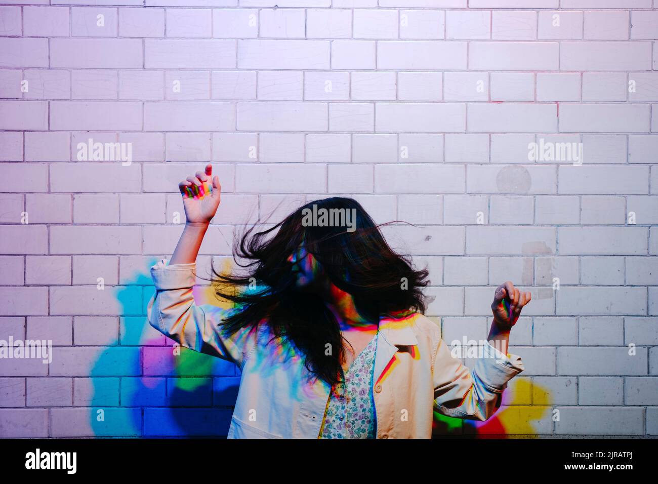 Young woman dancing in front of wall Stock Photo - Alamy