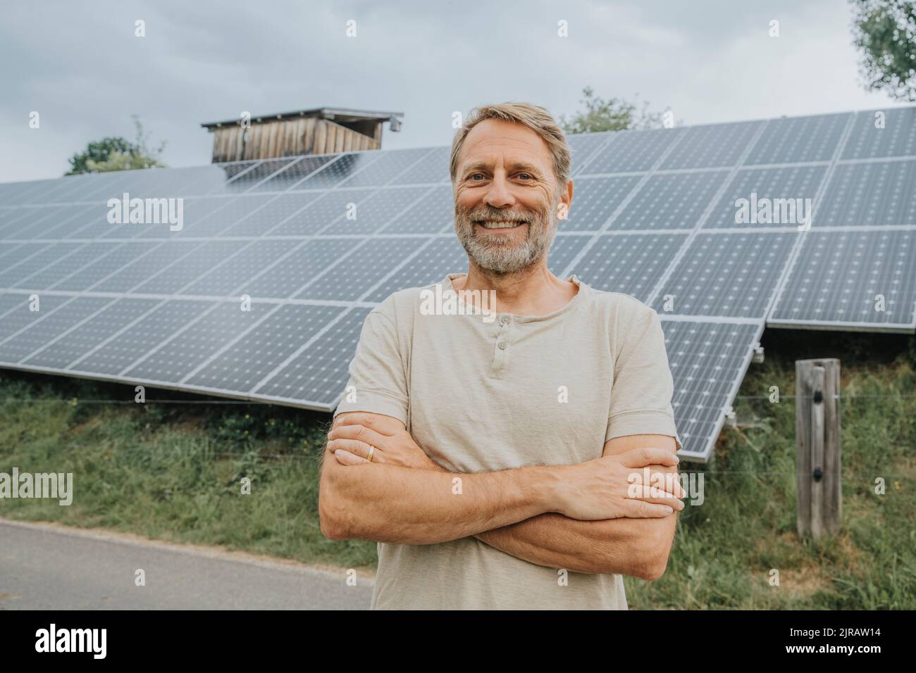Smiling man standing in front of solar panels Stock Photo - Alamy