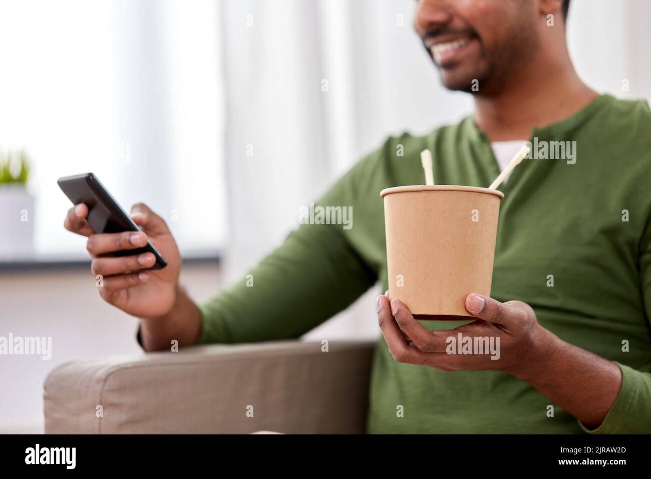 indian man with phone eating takeaway food at home Stock Photo - Alamy