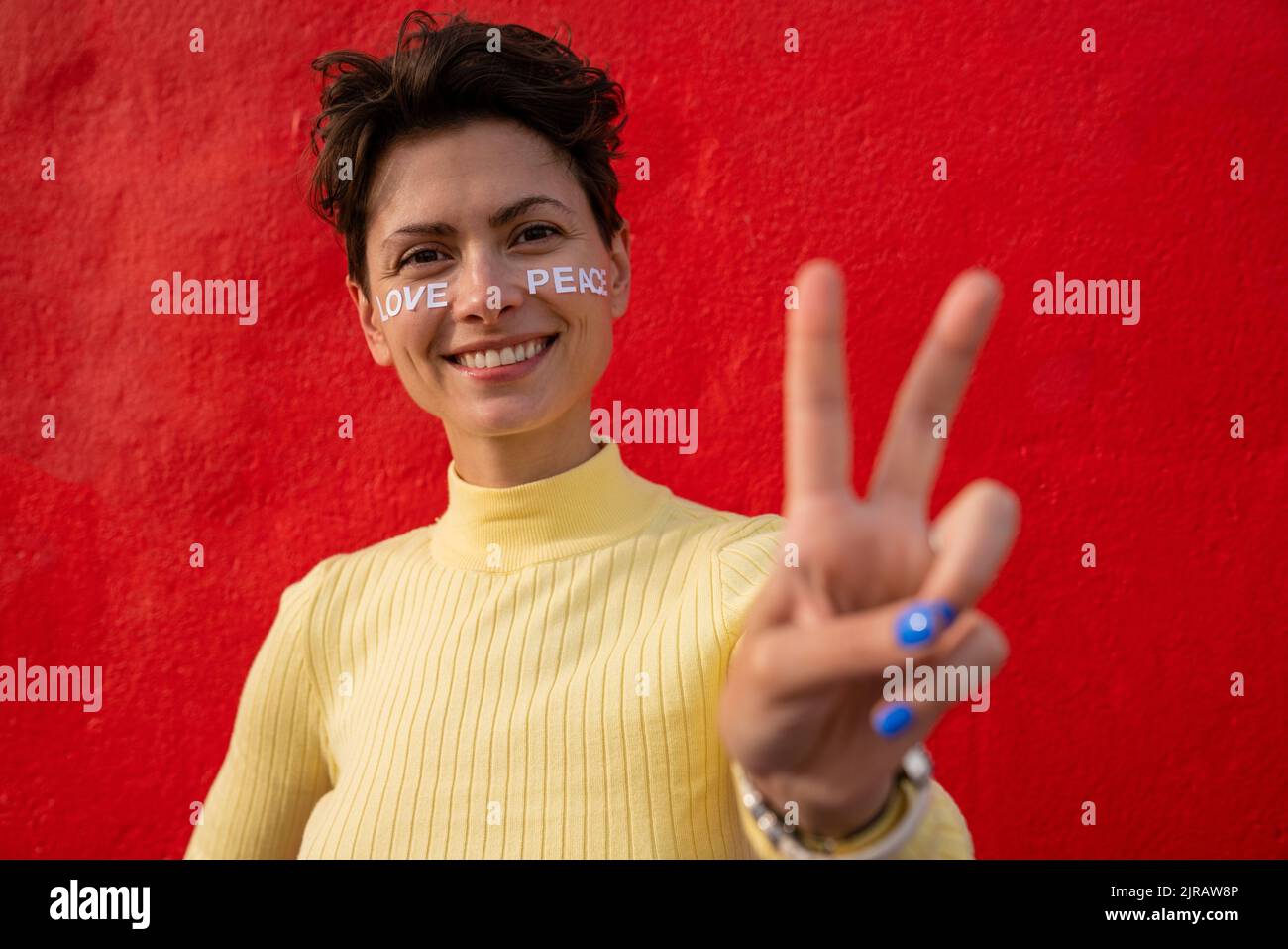 Woman smiling making peace sign hi-res stock photography and images - Alamy