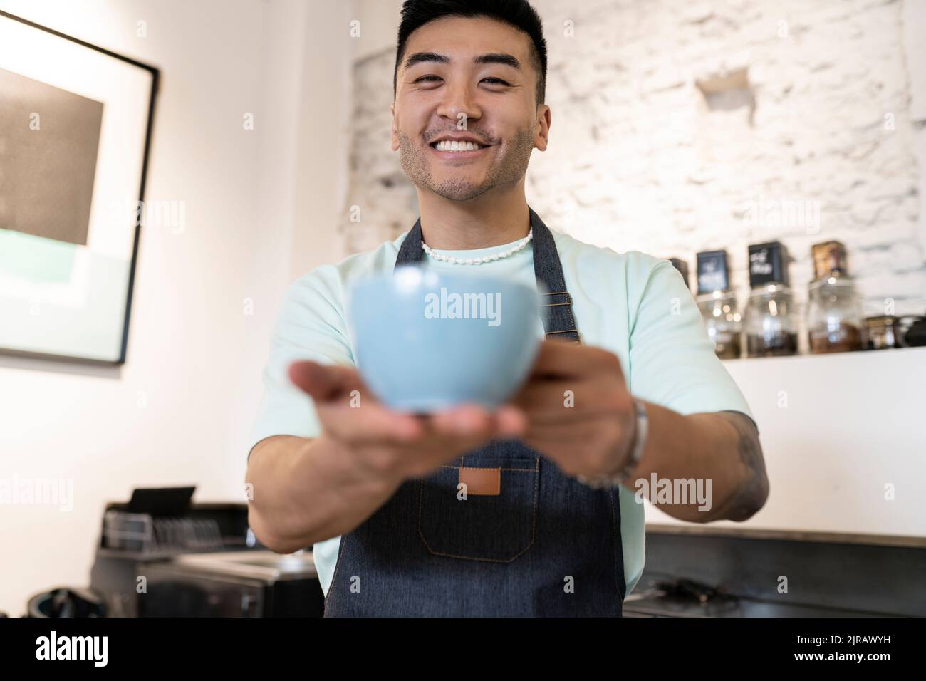 Happy man offering coffee cup Stock Photo - Alamy
