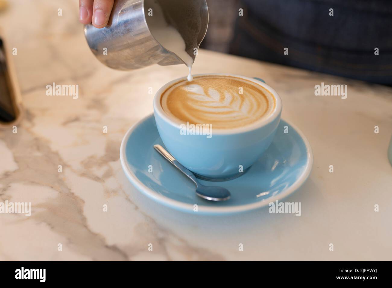 Hand of barista making froth art in coffee cup Stock Photo - Alamy