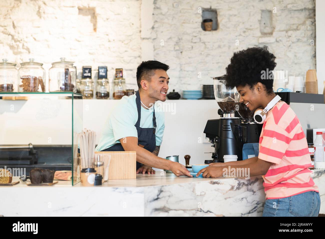Smiling man serving coffee to customer in cafe Stock Photo - Alamy