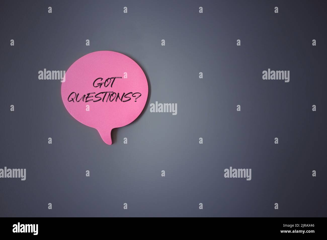 Top view image of speech bubble with text GOT QUESTIONS? on grey dark ...