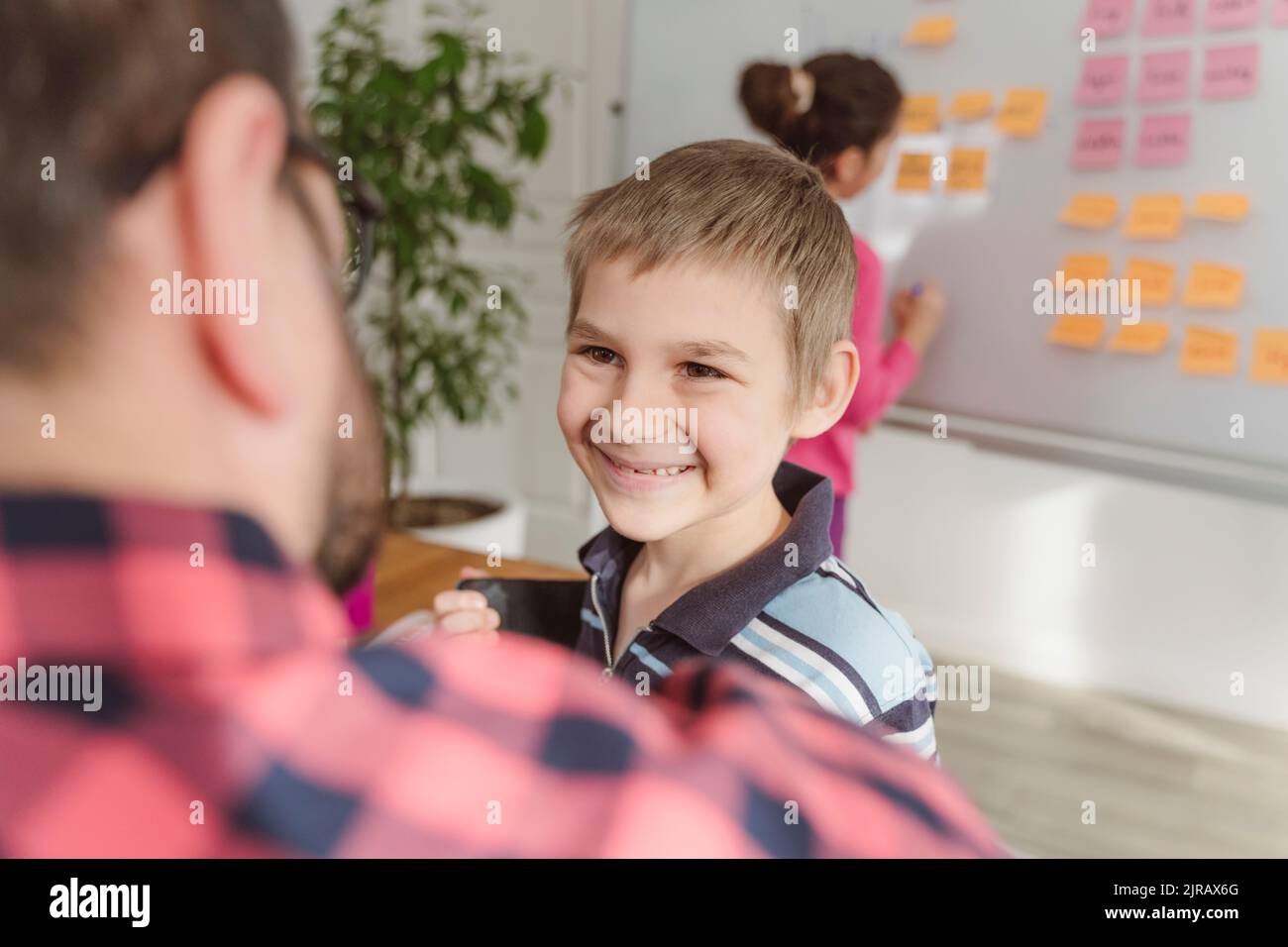Smiling boy looking at teacher in tuition Stock Photo - Alamy