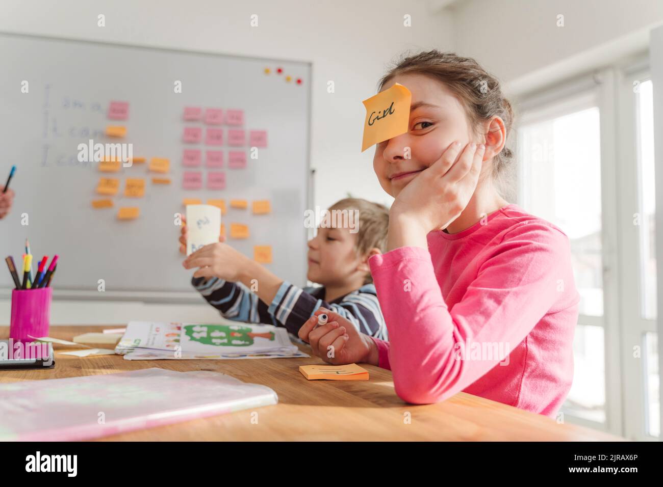 Girl with adhesive note on forehead by brother in tuition at home Stock ...