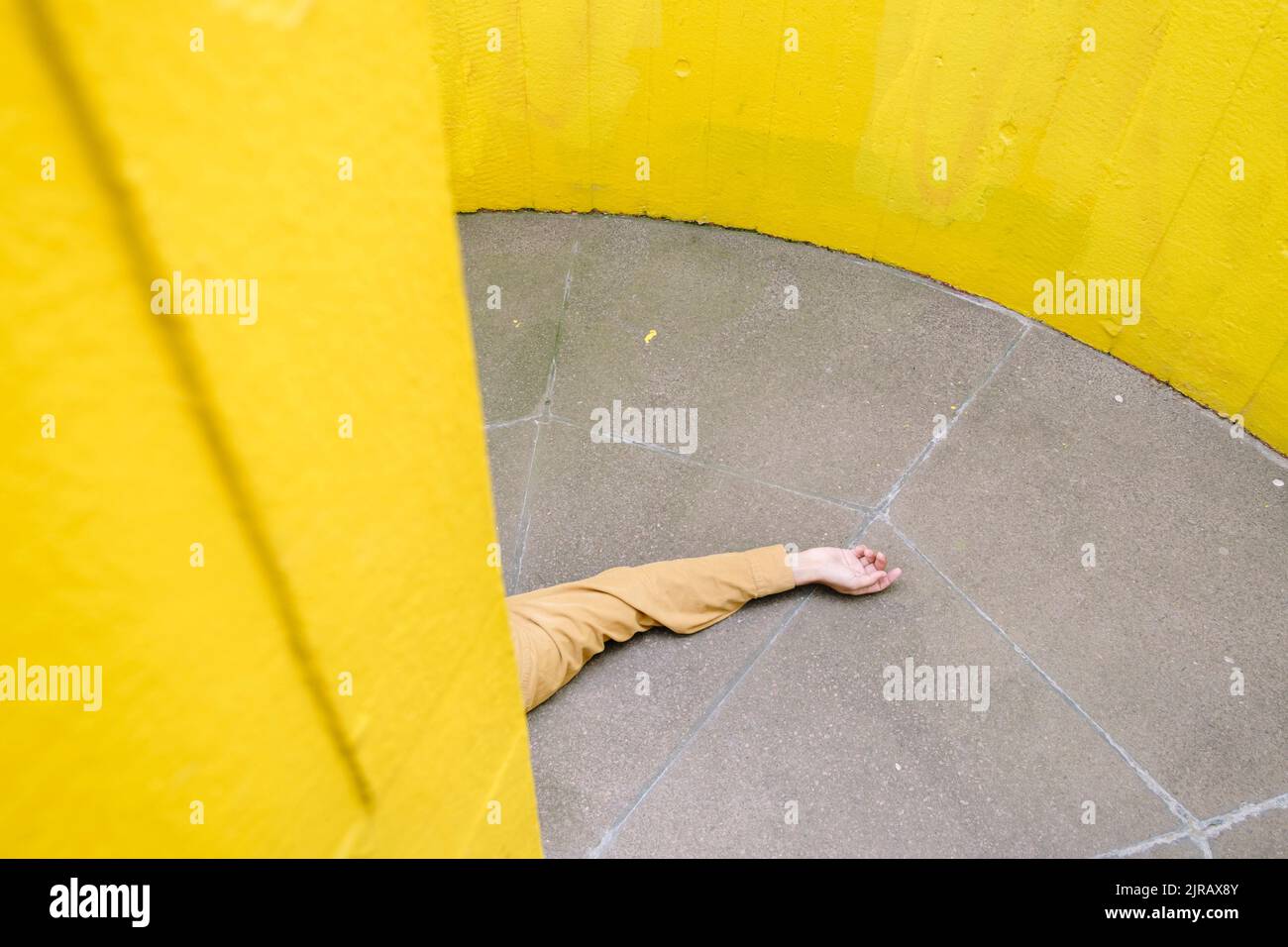 Hand of unconscious man on floor by yellow wall Stock Photo - Alamy