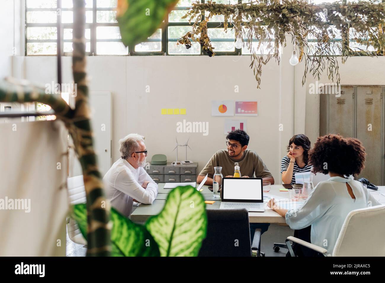 Coworkers discussing with each other at work place Stock Photo - Alamy