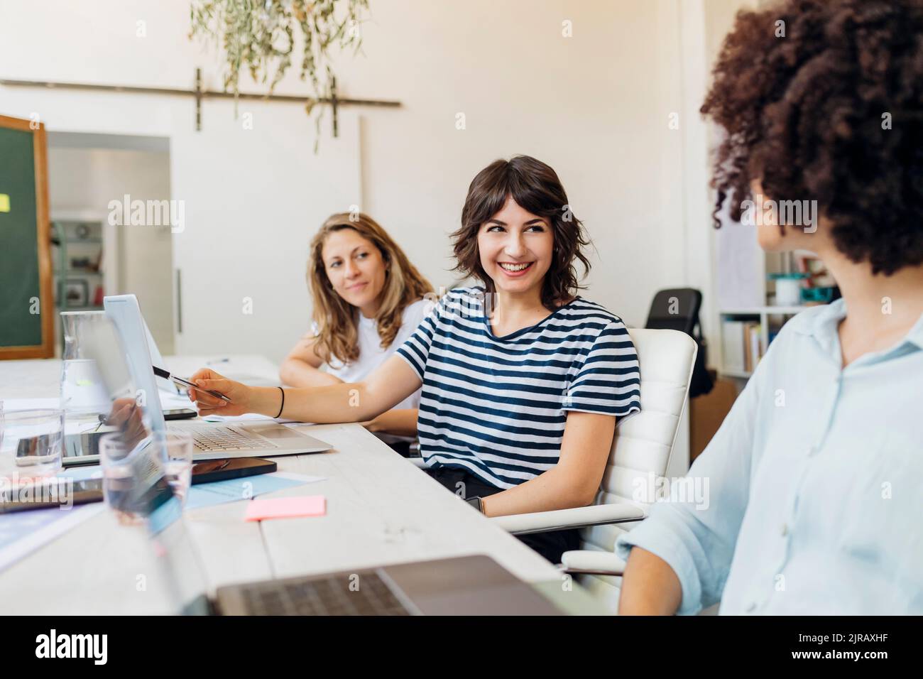 Happy business colleagues planning together at work place Stock Photo ...