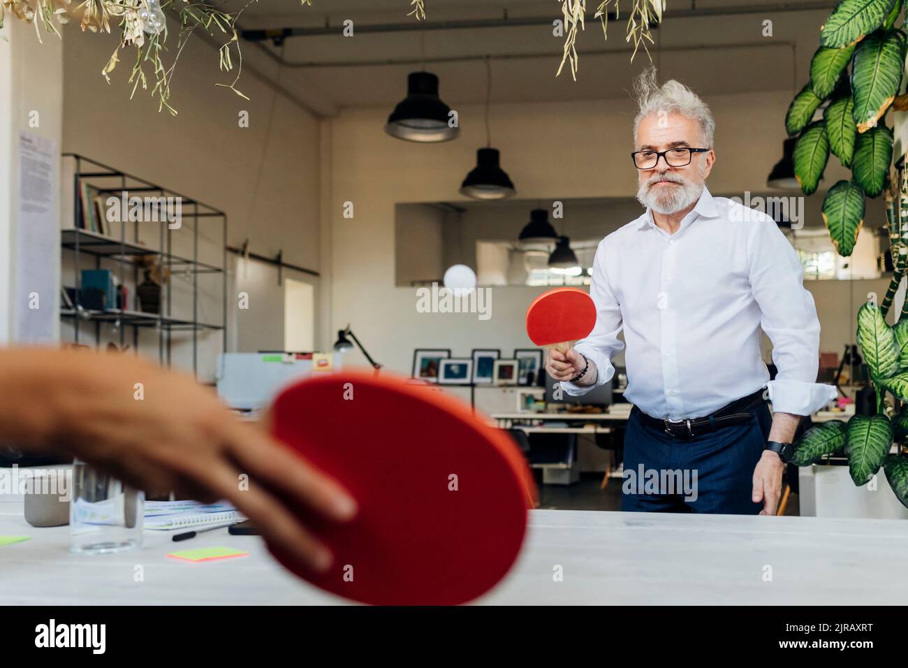 While colleagues playing table tennis hi-res stock photography and ...
