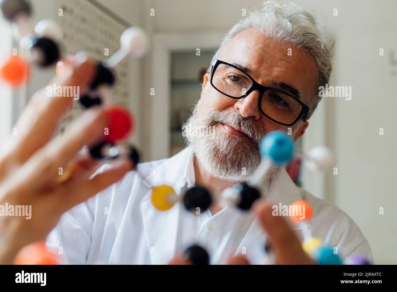 Scientist wearing eyeglasses looking at molecular structure Stock Photo ...