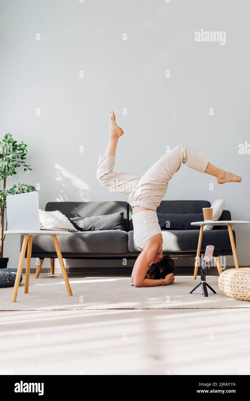 Woman practicing yoga laptop female hi-res stock photography and images ...