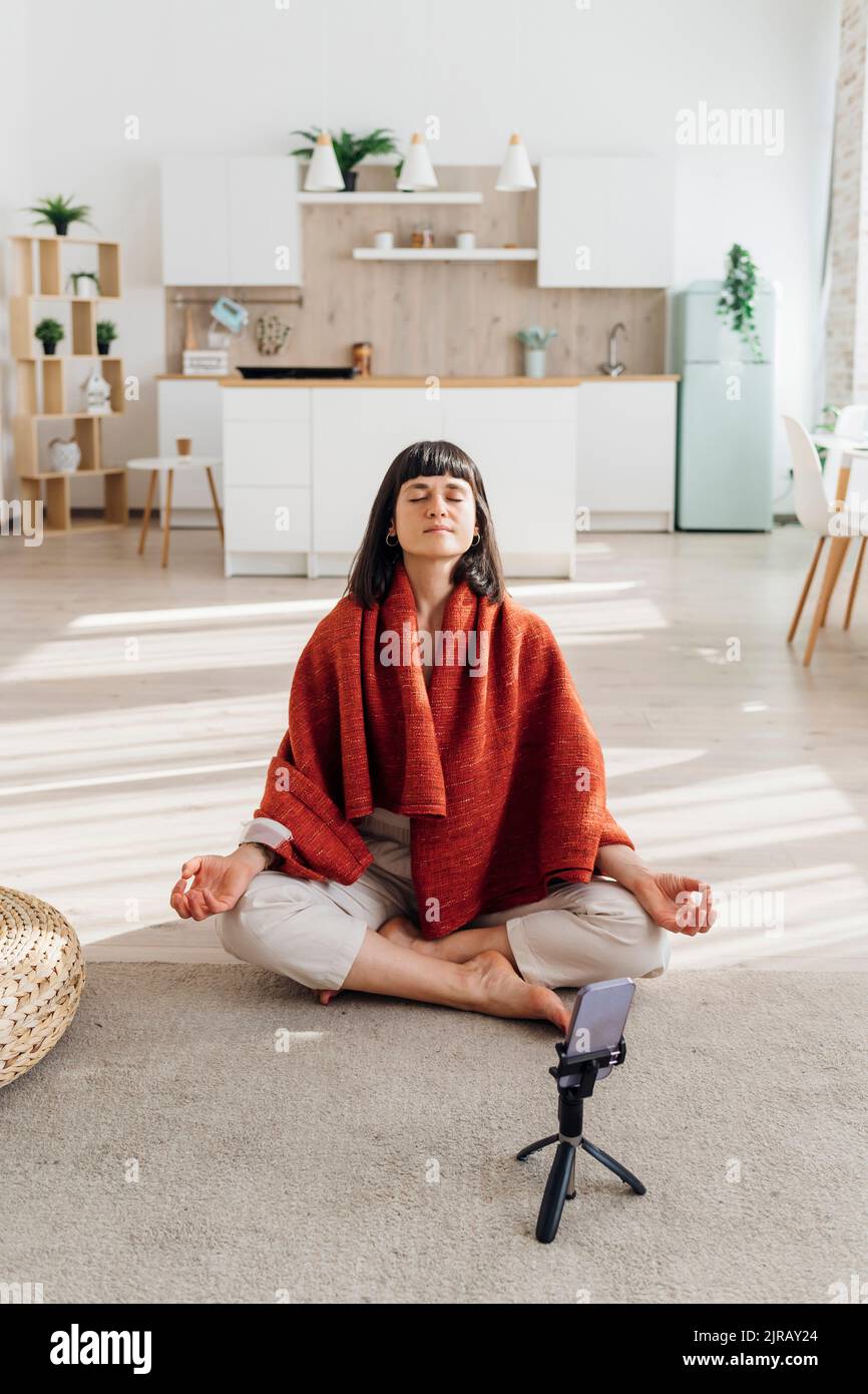 Woman meditating sitting cross-legged at home Stock Photo - Alamy