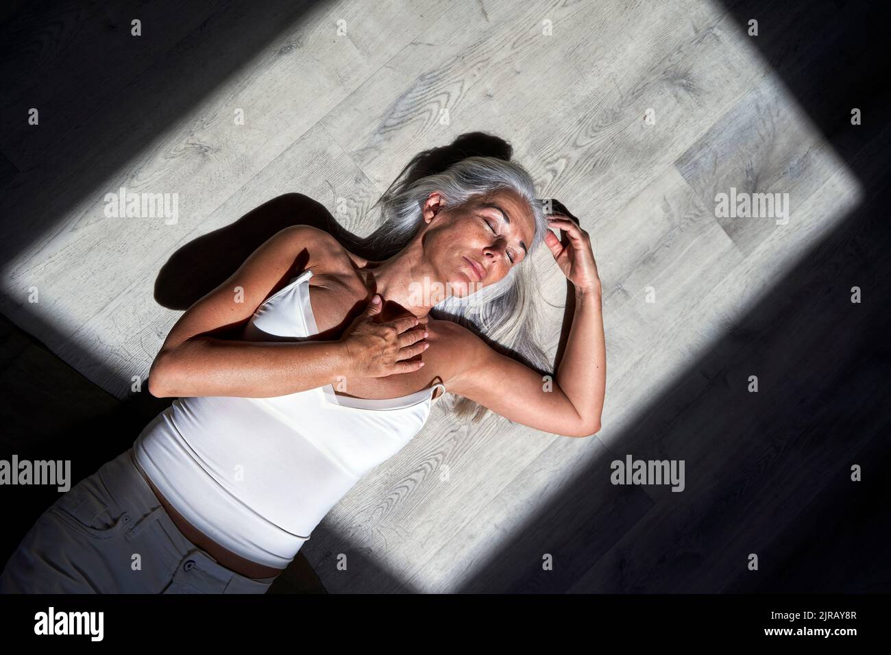 Woman relaxing on floor lying under sunlight Stock Photo - Alamy