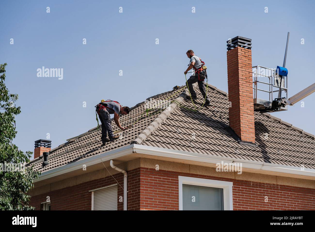 Technicians working on house rooftop Stock Photo - Alamy