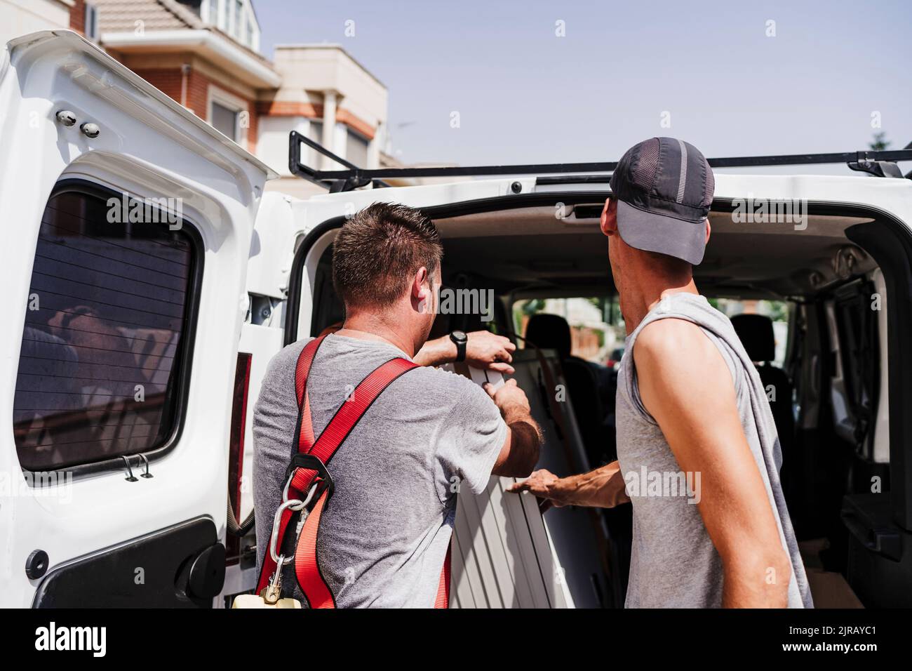 Electricians unloading solar panels from van Stock Photo - Alamy
