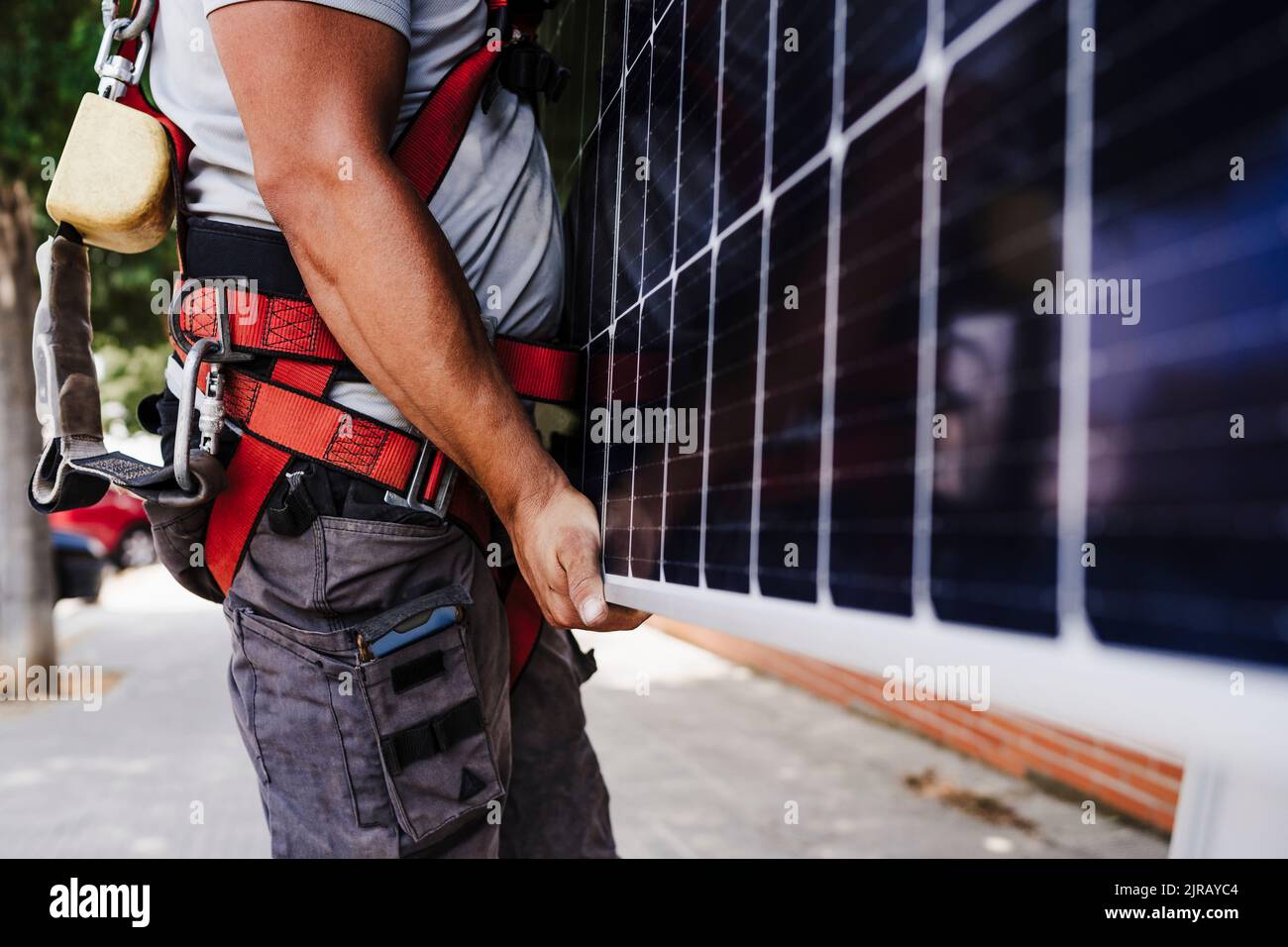 Technician carrying heavy solar panel Stock Photo - Alamy