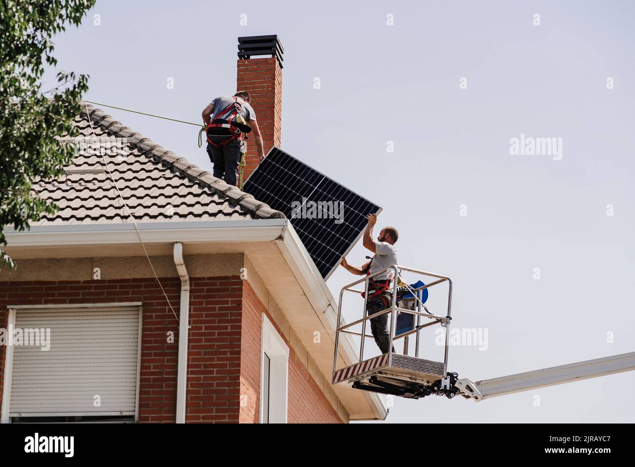Technicians installing solar panels on rooftop Stock Photo - Alamy