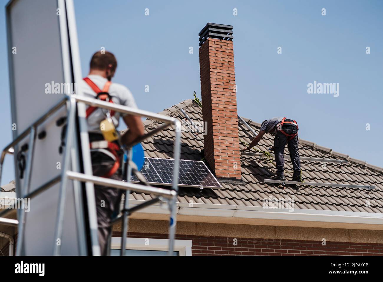 Craftsmen installing solar panels on house roof Stock Photo - Alamy