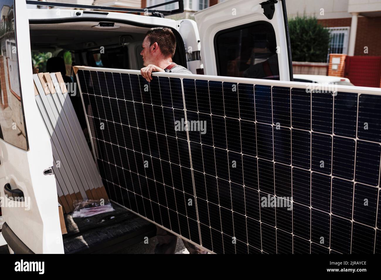 Technician unloading solar panels from van Stock Photo - Alamy