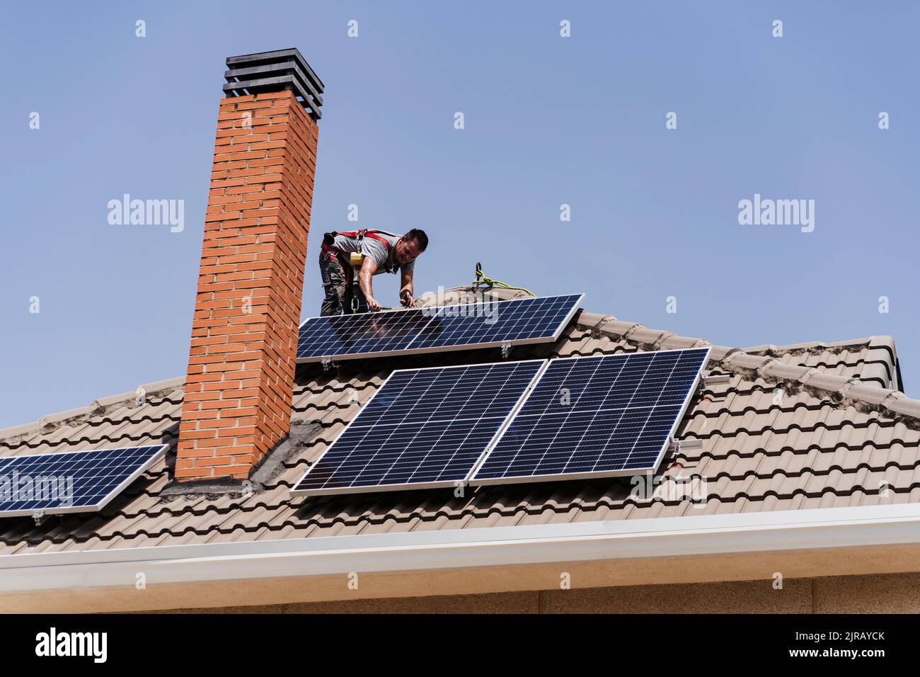 Technician installing solar panels on house rooftop at sunny day Stock Photo - Alamy
