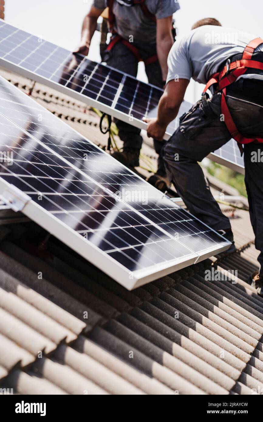 Electrician coworkers installing solar panels on rooftop Stock Photo - Alamy
