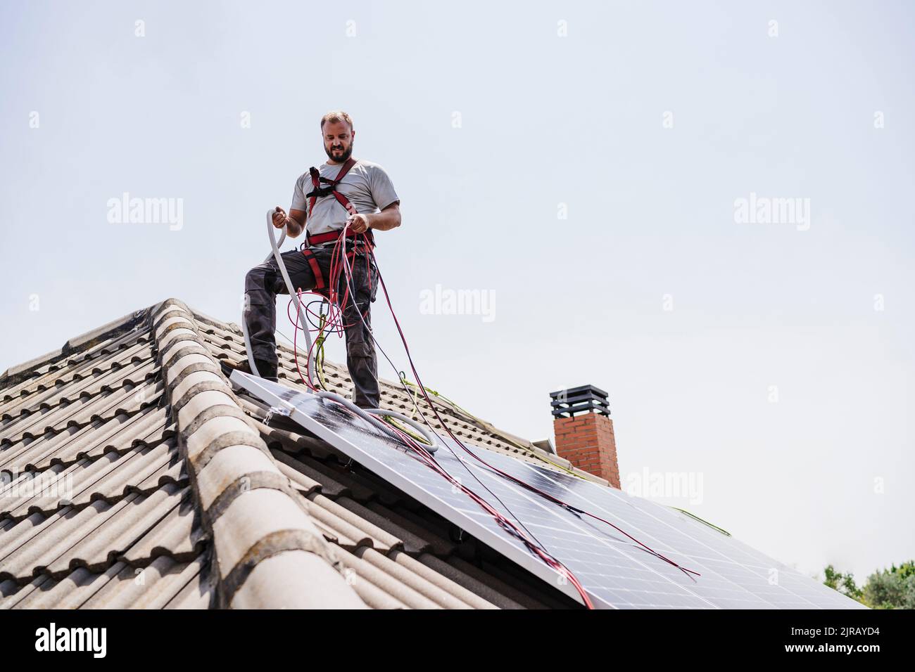 Craftsman installing solar panels on rooftop Stock Photo - Alamy
