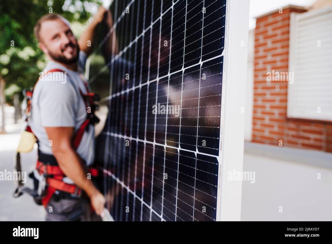 Craftsman carrying heavy solar panel Stock Photo - Alamy