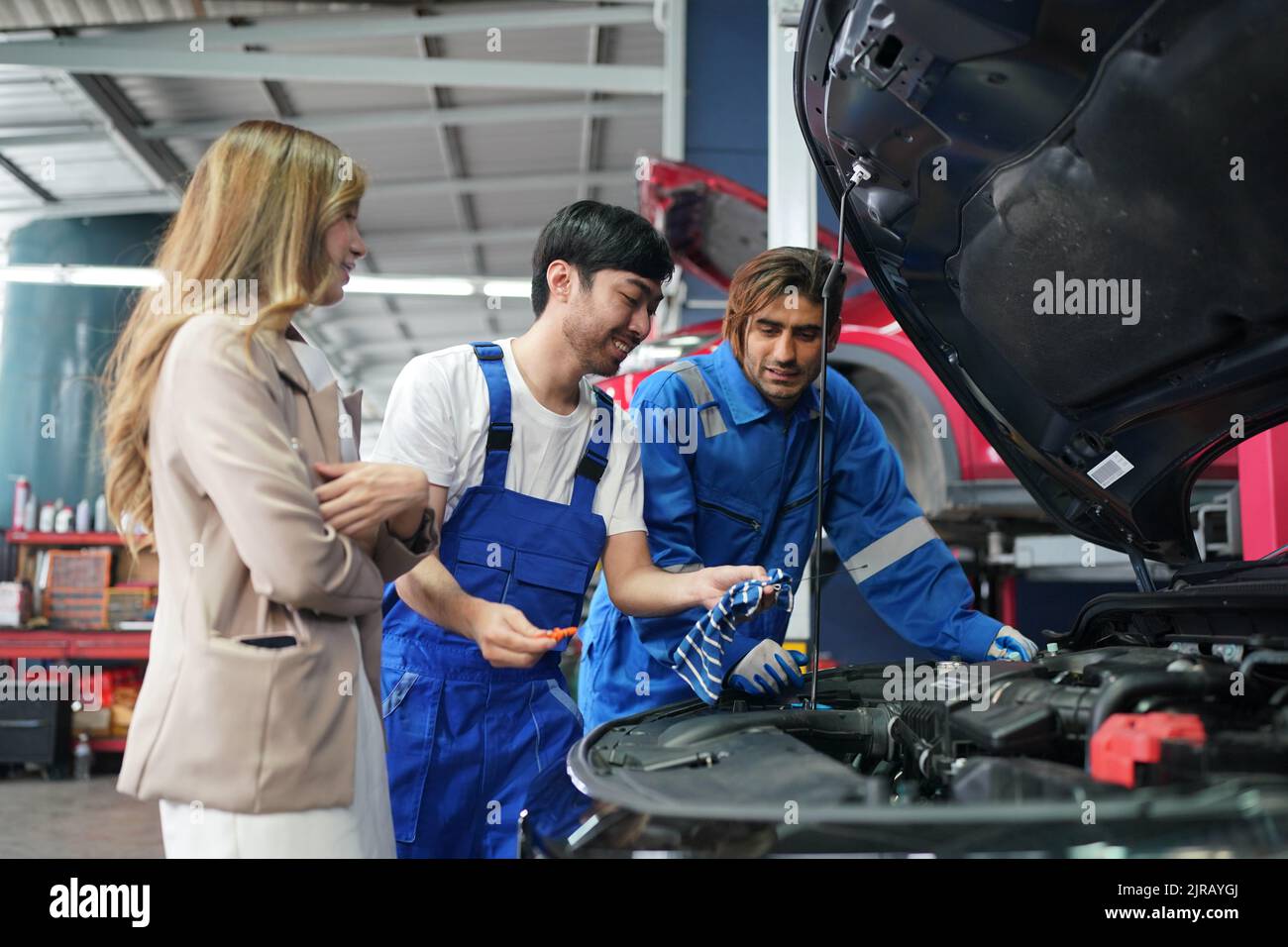 Male car operator wearing blue overalls,cap and gloves working under ...