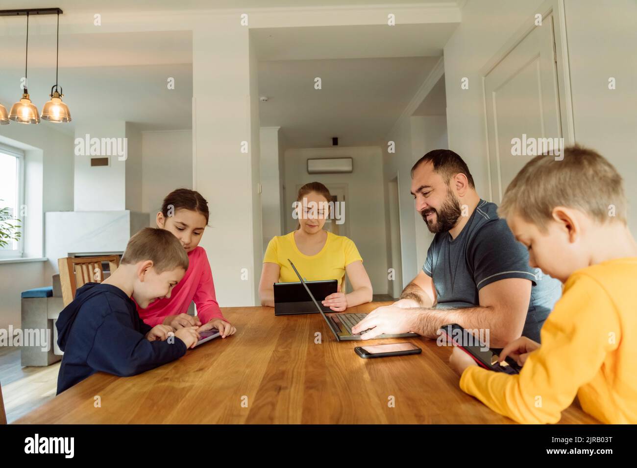 Parents with children using wireless technologies at home Stock Photo ...