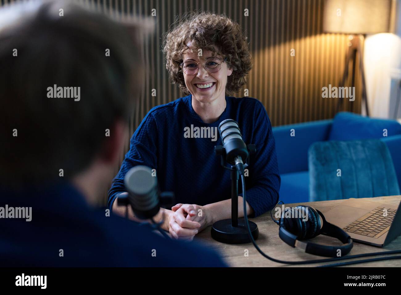 Happy presenter interviewing guest in recording studio Stock Photo - Alamy