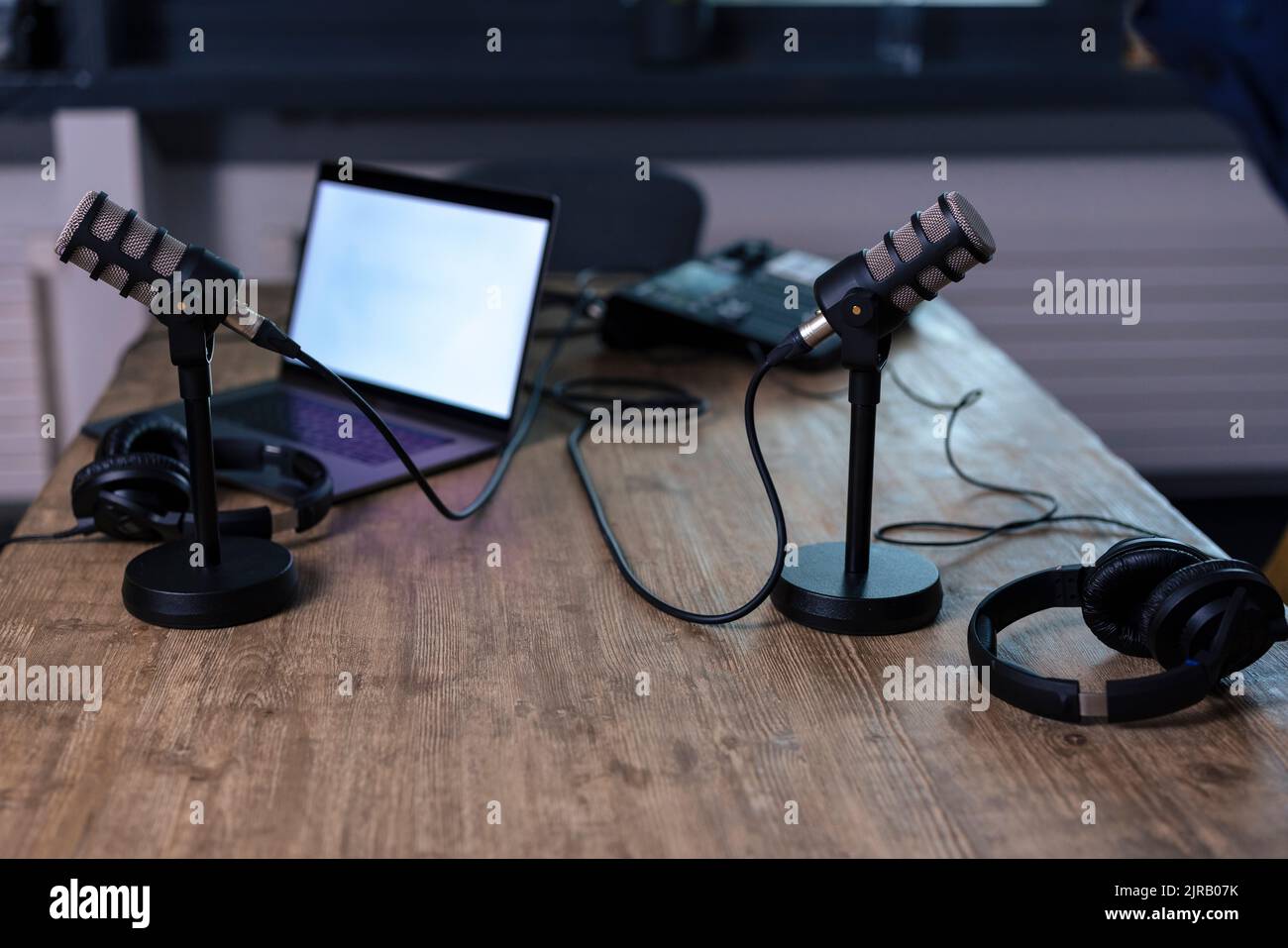 Microphones with headset and laptop on desk in recording studio Stock ...