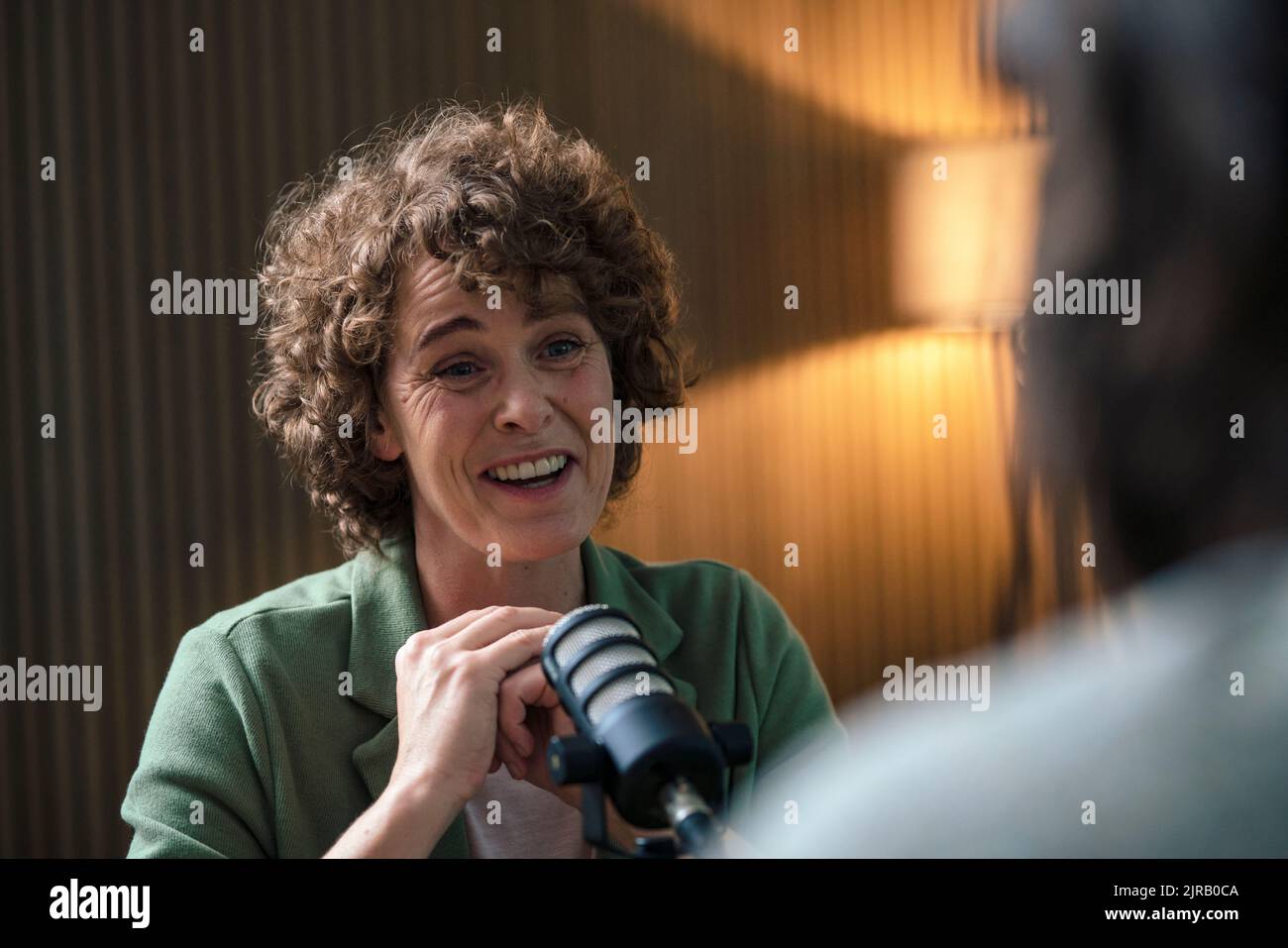 Happy presenter discussing with guest at radio station Stock Photo - Alamy