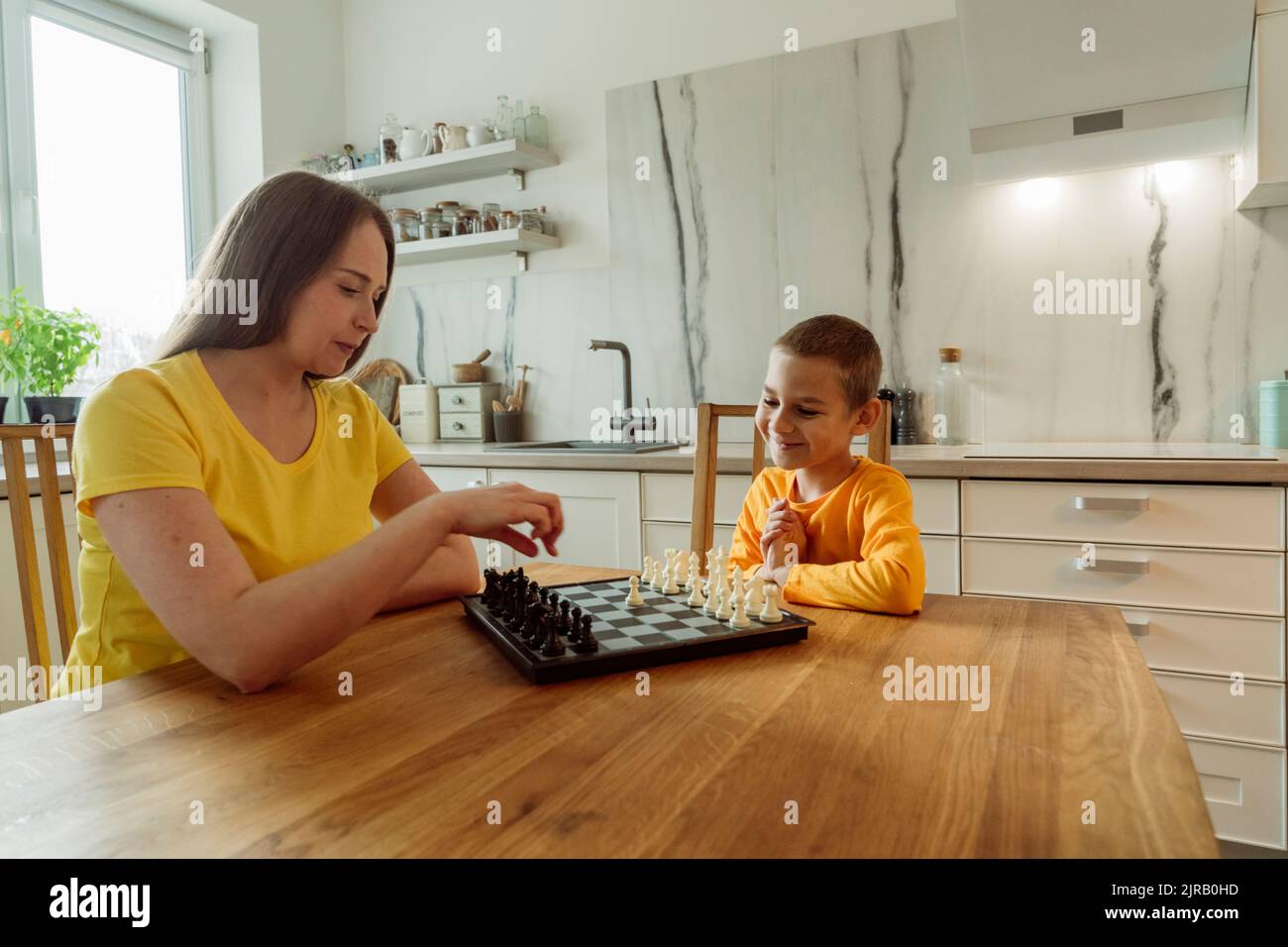 Mother and son playing chess in domestic kitchen Stock Photo - Alamy