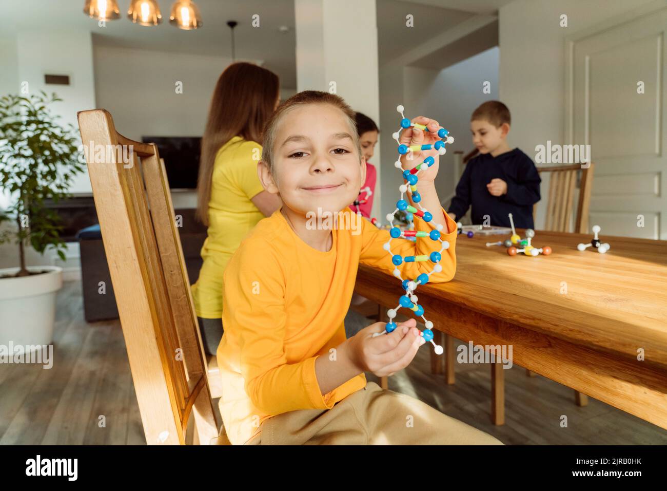Boy with DNA model at table by family at home Stock Photo - Alamy