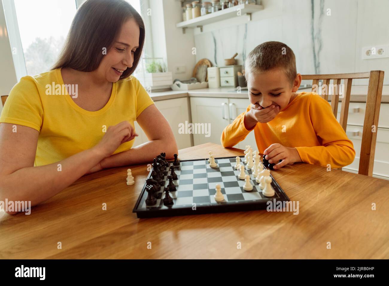 Smiling mother and son playing chess at home Stock Photo - Alamy