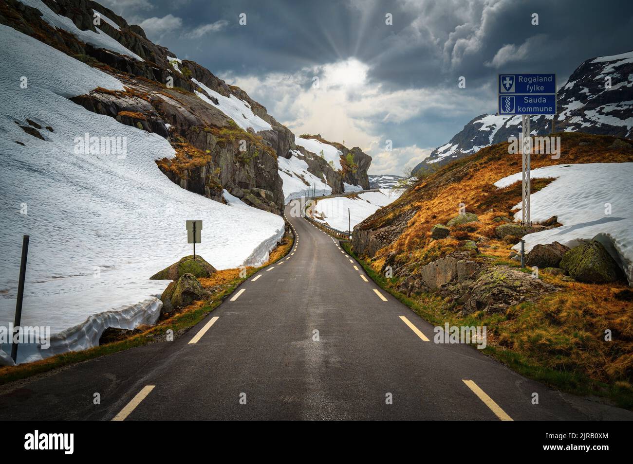 Norway, Rogaland, Sauda, Road 520 stretching between snow-covered hills ...