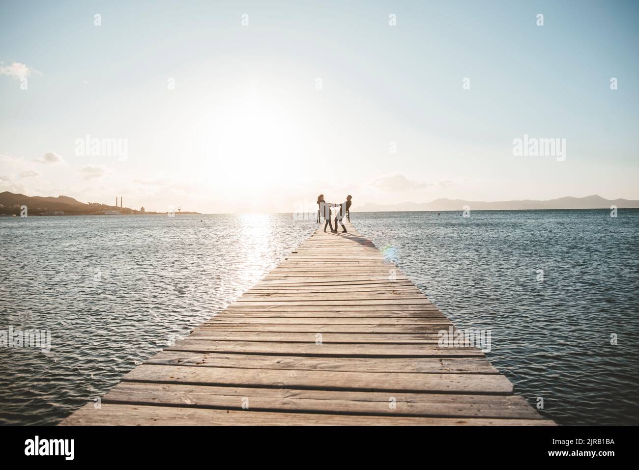 Happy couple enjoying on jetty over sea Stock Photo - Alamy