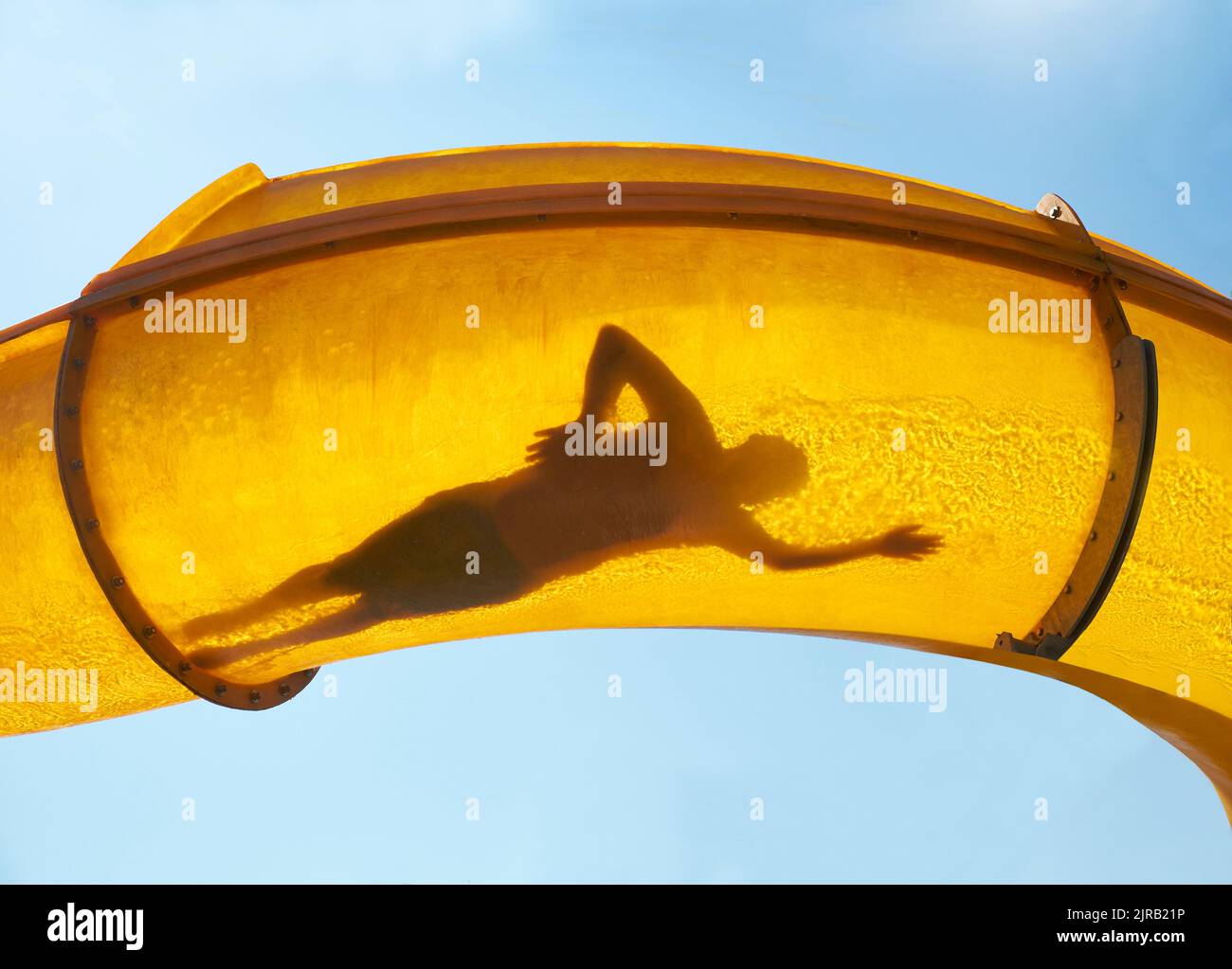 Silhouette of person sliding down water slide Stock Photo - Alamy