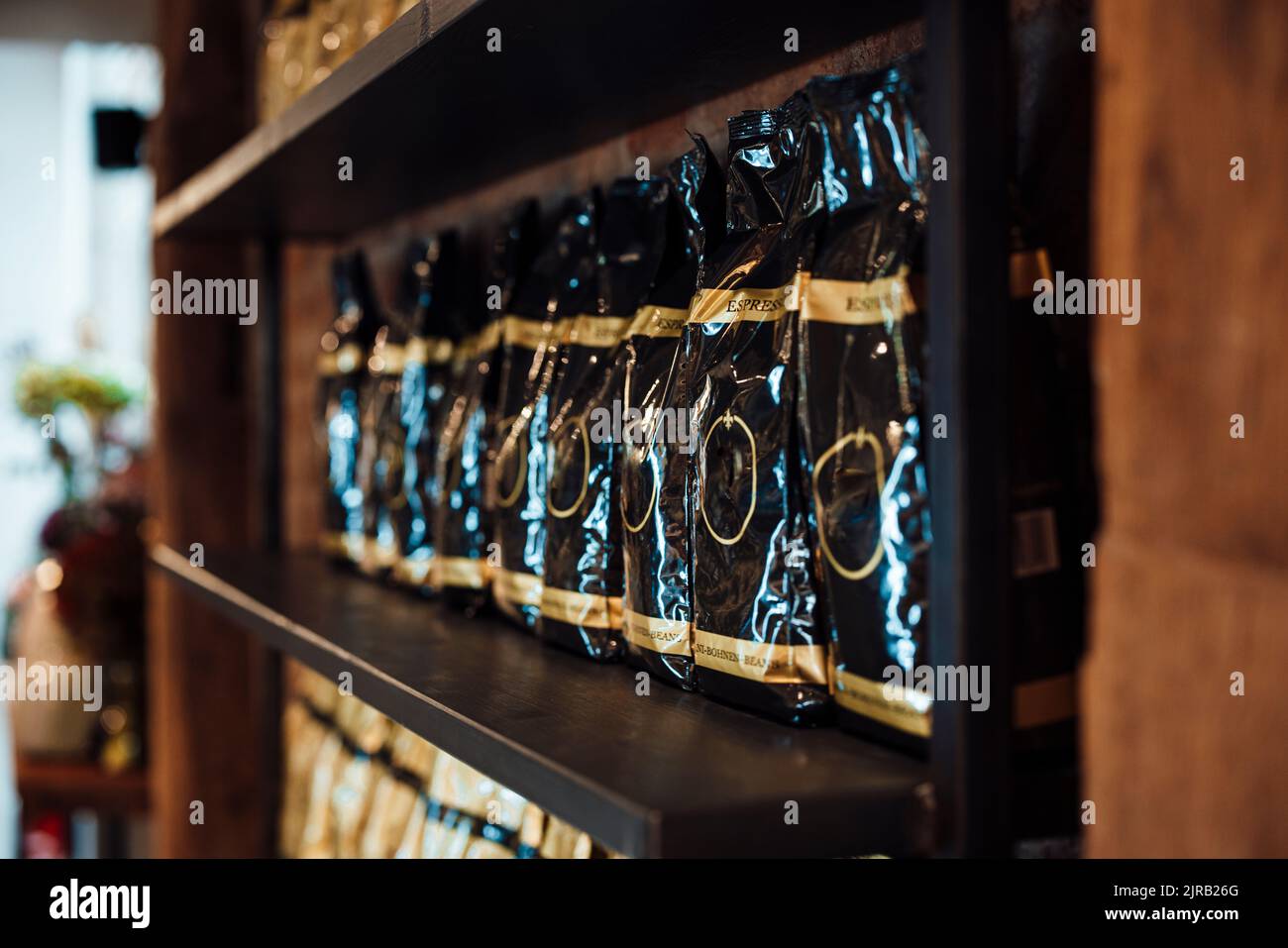 Coffee packets arranged on rack at cafe Stock Photo - Alamy