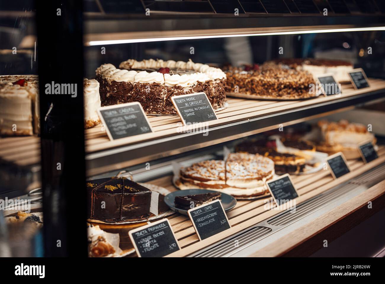 Varieties of cakes arranged on retail display at cafe Stock Photo - Alamy