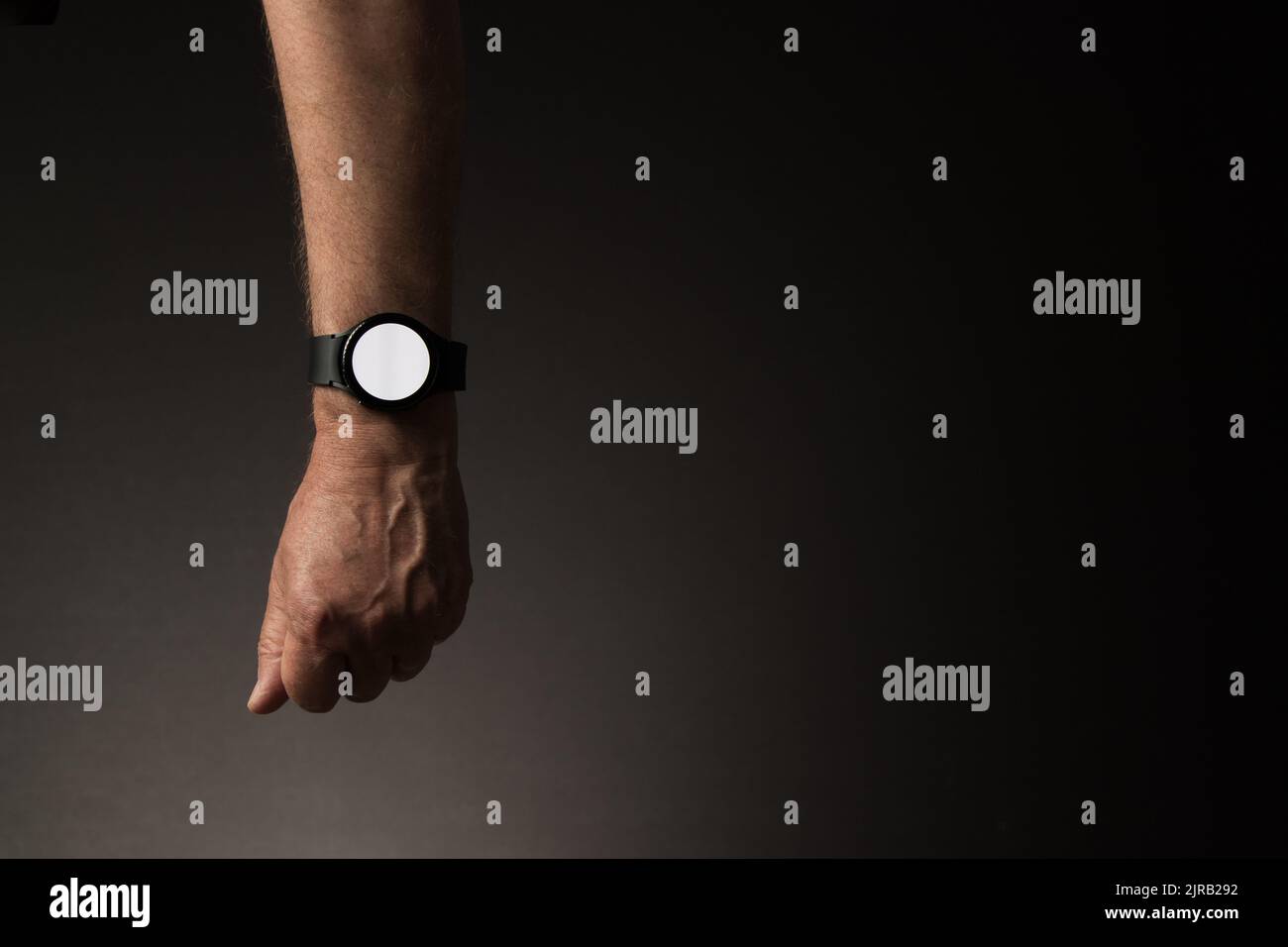 Man's hand with smart watch on wrist, displaying blank white screen ...