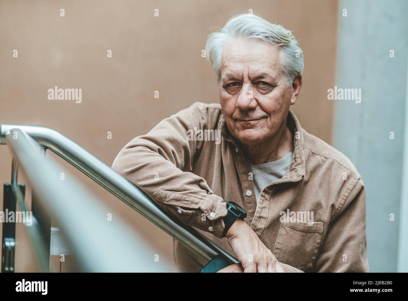 Smiling senior man leaning on railing Stock Photo - Alamy