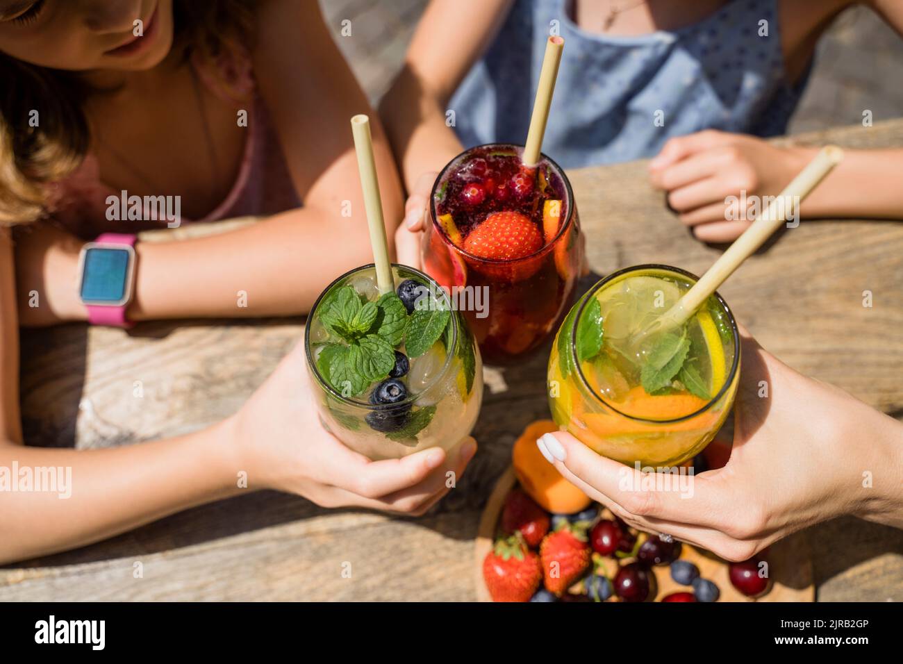 Hands of woman and girls toasting cocktails with cane straw Stock Photo ...