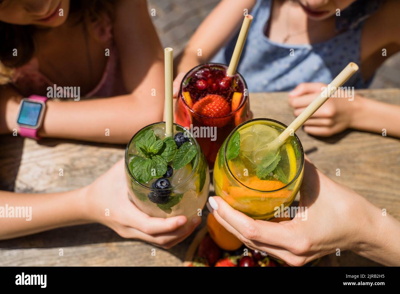Hands of mother and daughters toasting cocktails with cane straw Stock ...