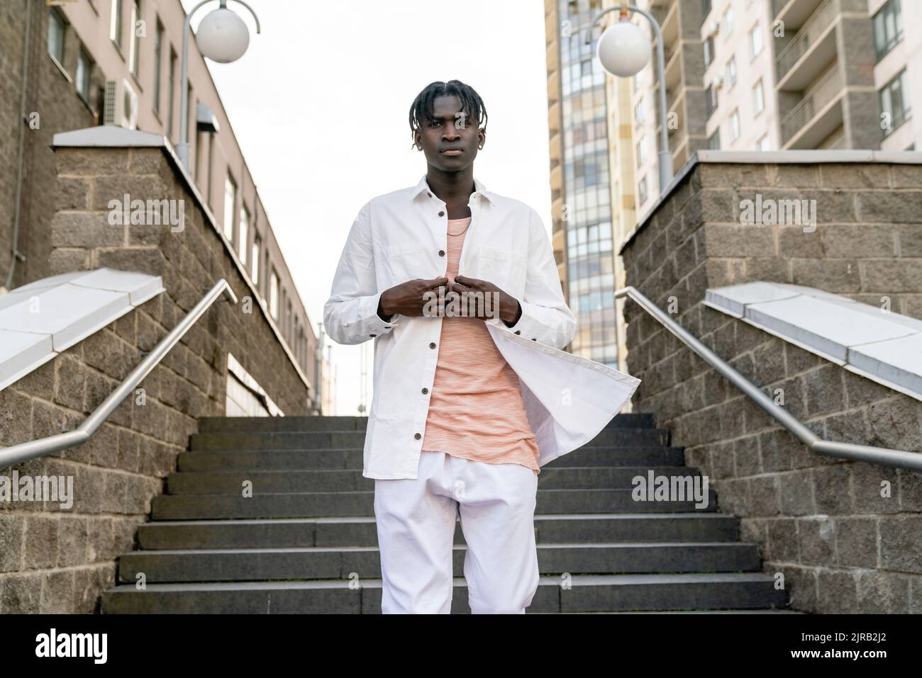 Young man standing in front of steps Stock Photo - Alamy