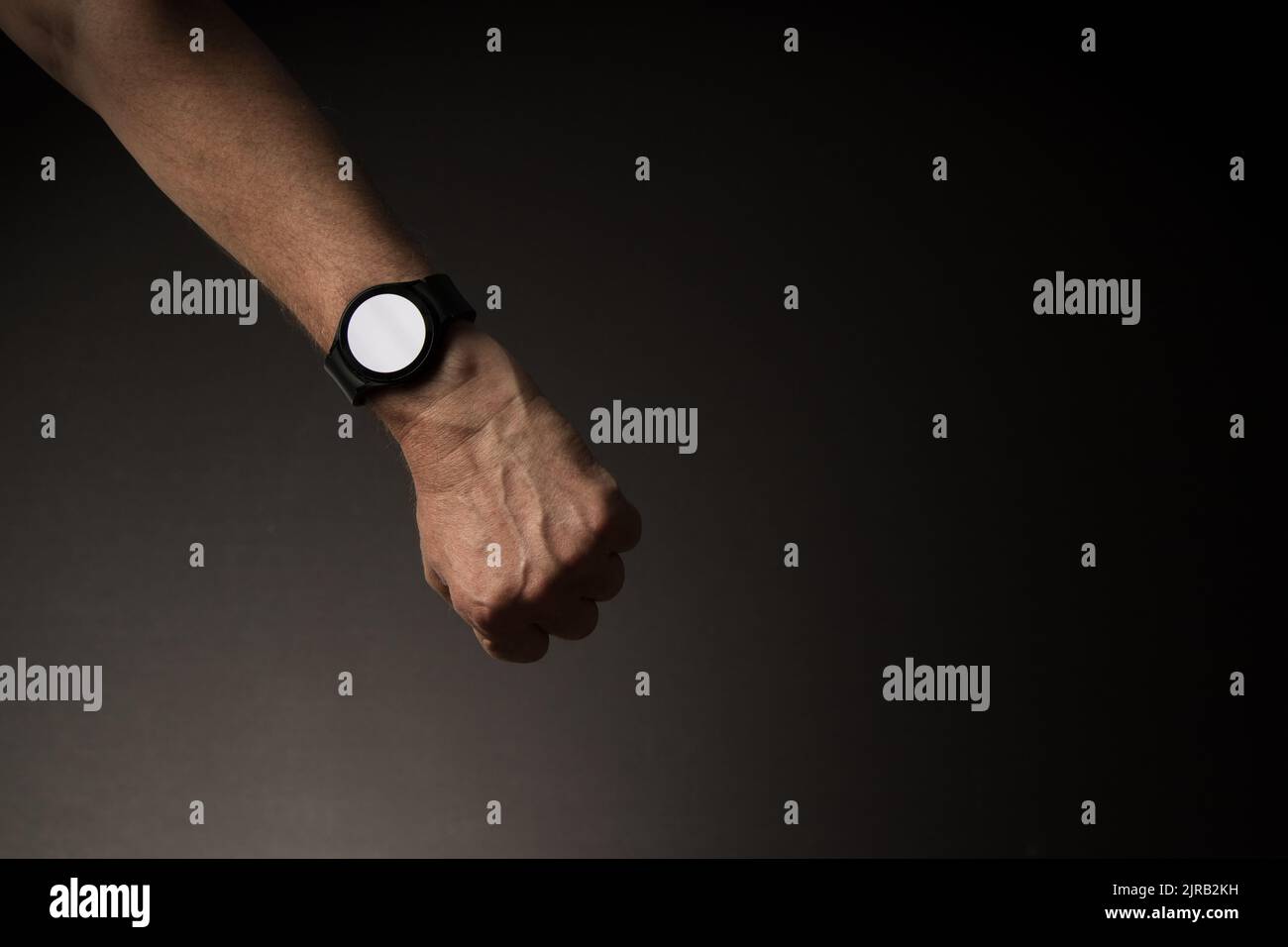 Man's hand with smart watch on wrist, displaying blank white screen ...