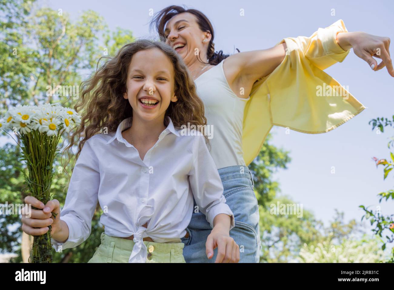 Happy mother and daughter dancing in park Stock Photo - Alamy