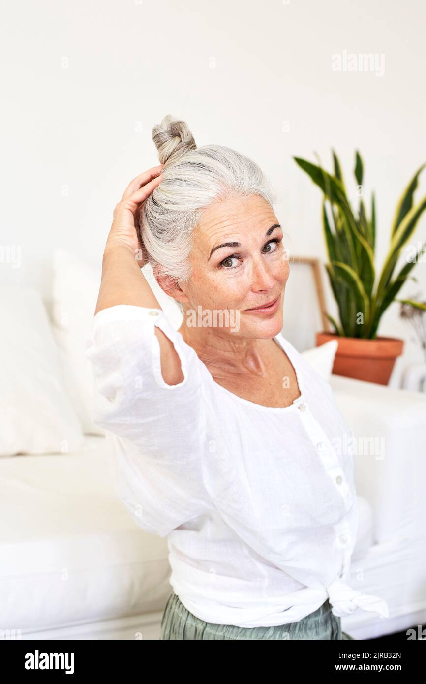 Woman tying hair bun hi-res stock photography and images - Alamy