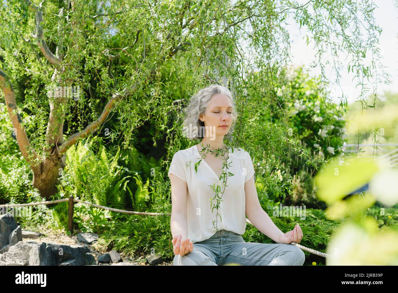 Woman in a park meditating hi-res stock photography and images - Alamy